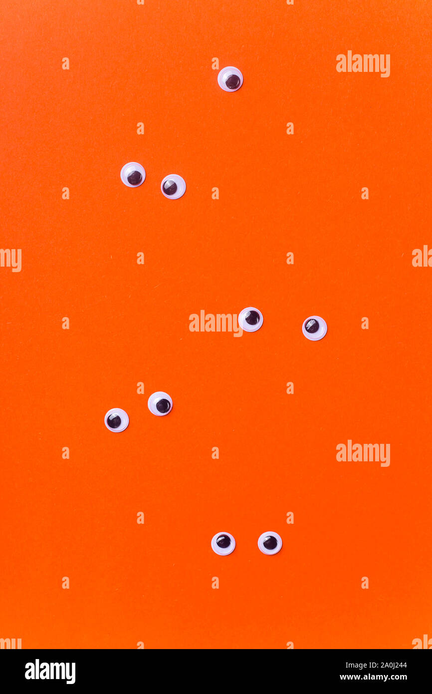 Scary ghost eyes on a bright orange background as a symbol of Halloween ...