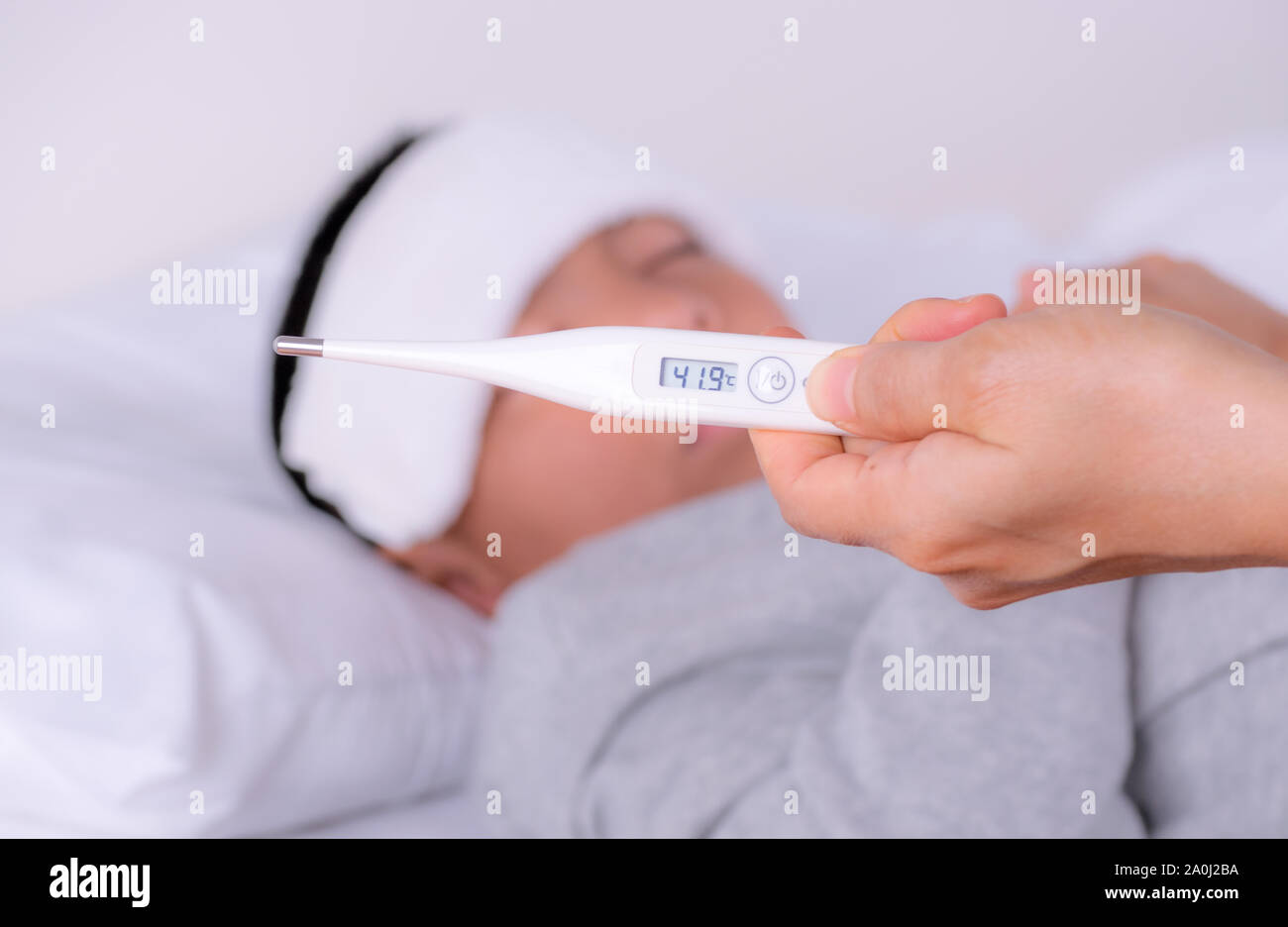 Woman hand holding a thermometer to measure the temperature on a ...
