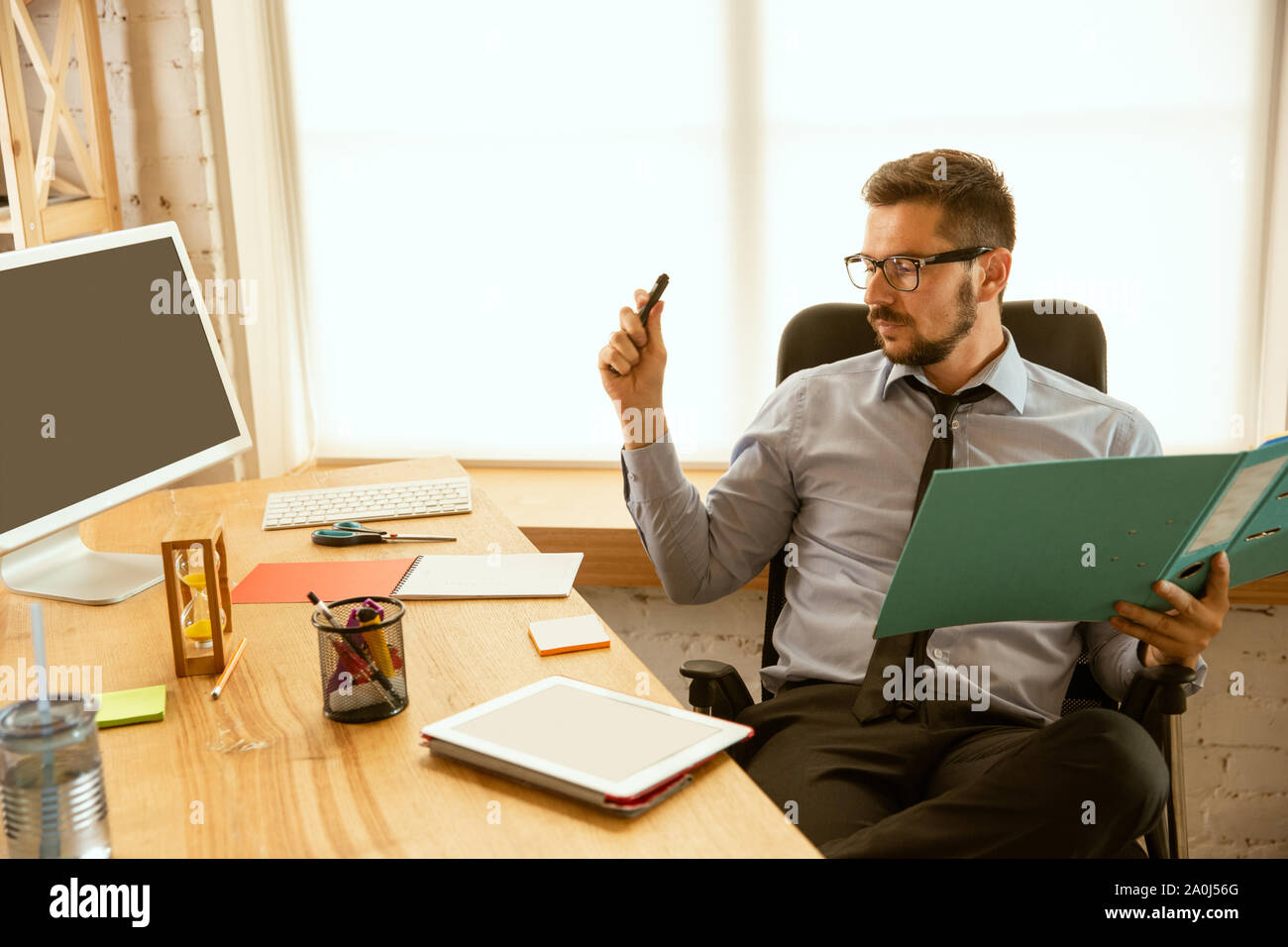 Deals. A young businessman working in the office, getting new work ...