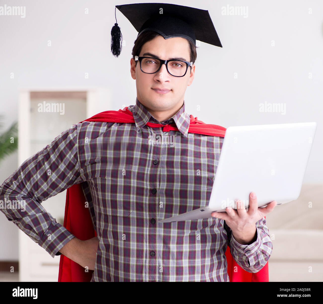 The super hero student wearing mortarboard and holding a laptop Stock ...