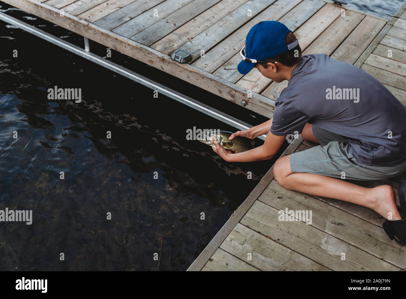 Boy fishing off dock in hi-res stock photography and images - Alamy