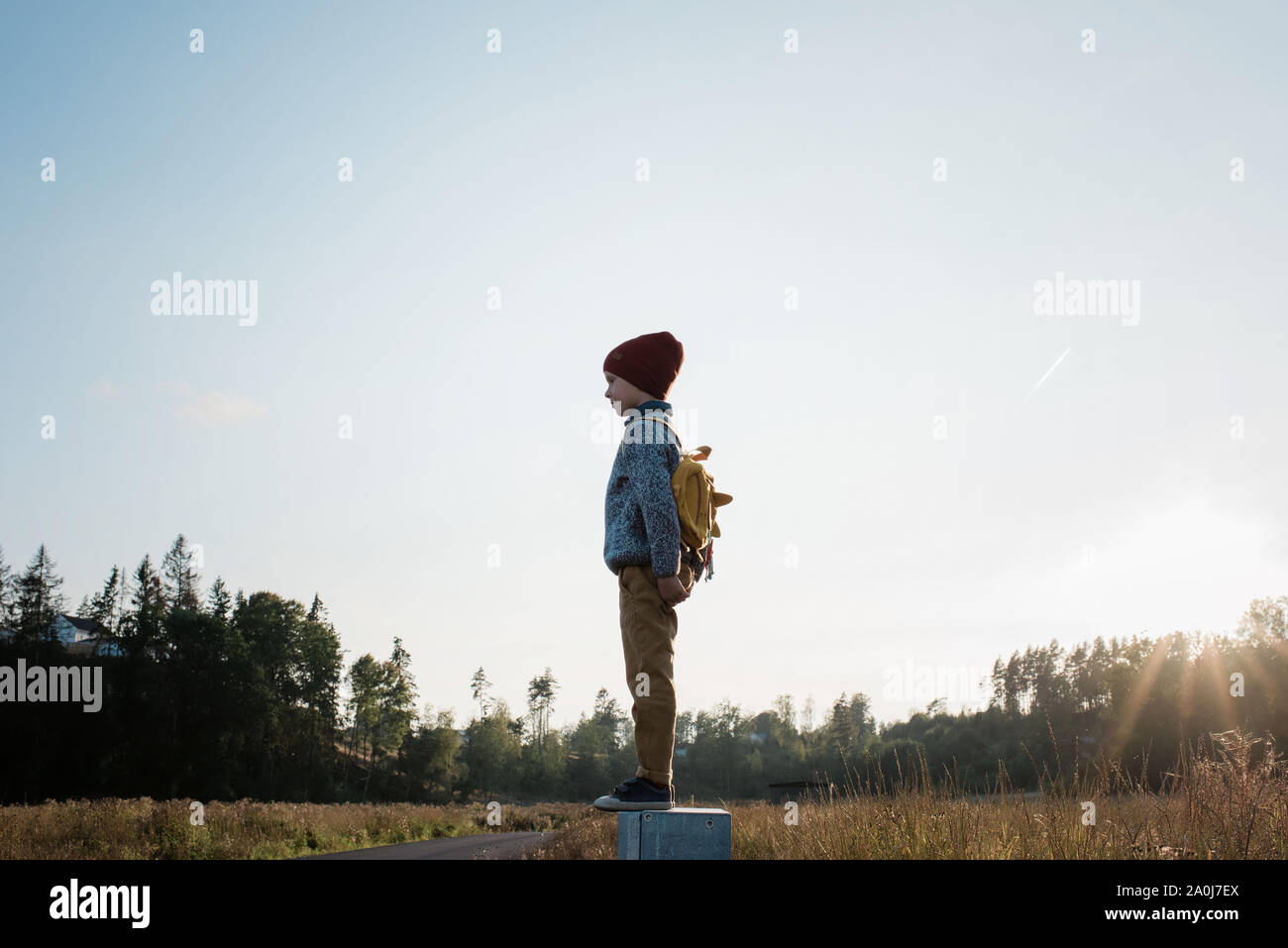 young school boy stood on a post playing whilst walking home Stock ...