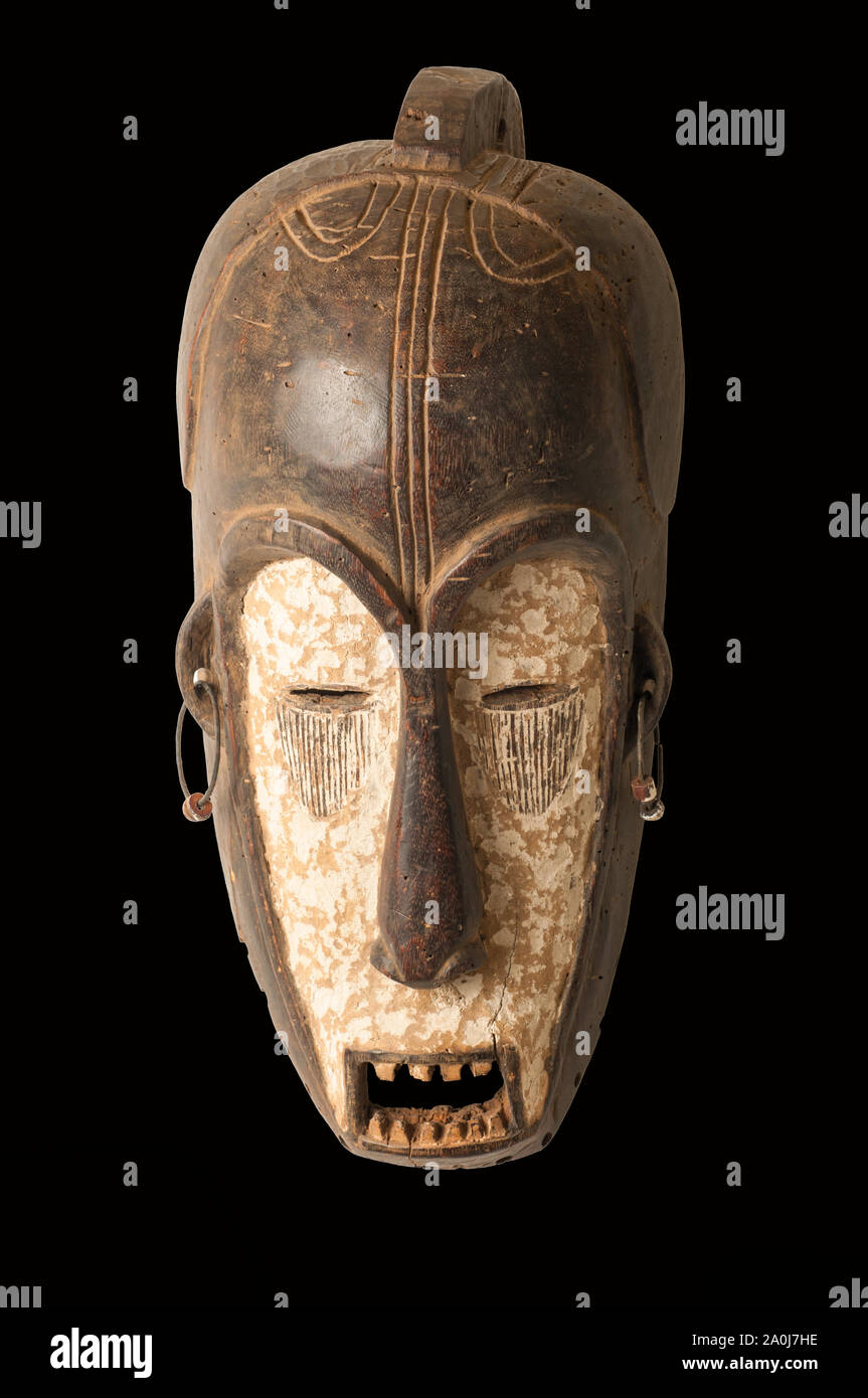 An African ceremonial mask in the form of a female figure carved in ...