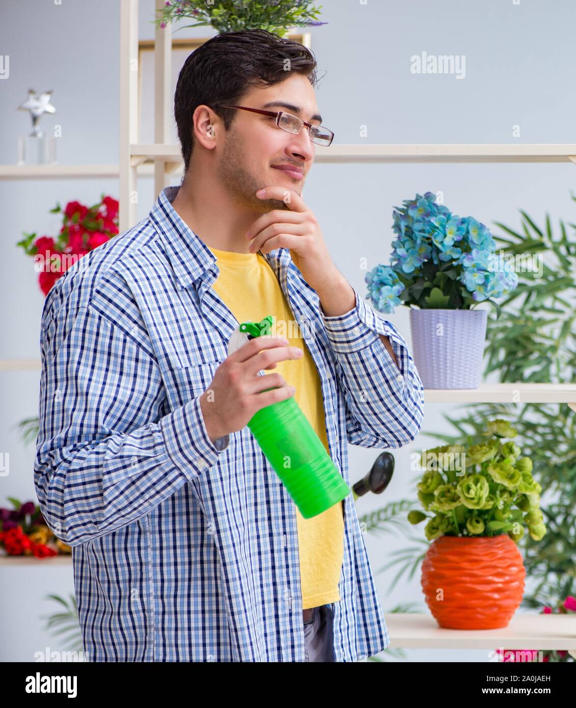 The young man florist working in a flower shop Stock Photo - Alamy