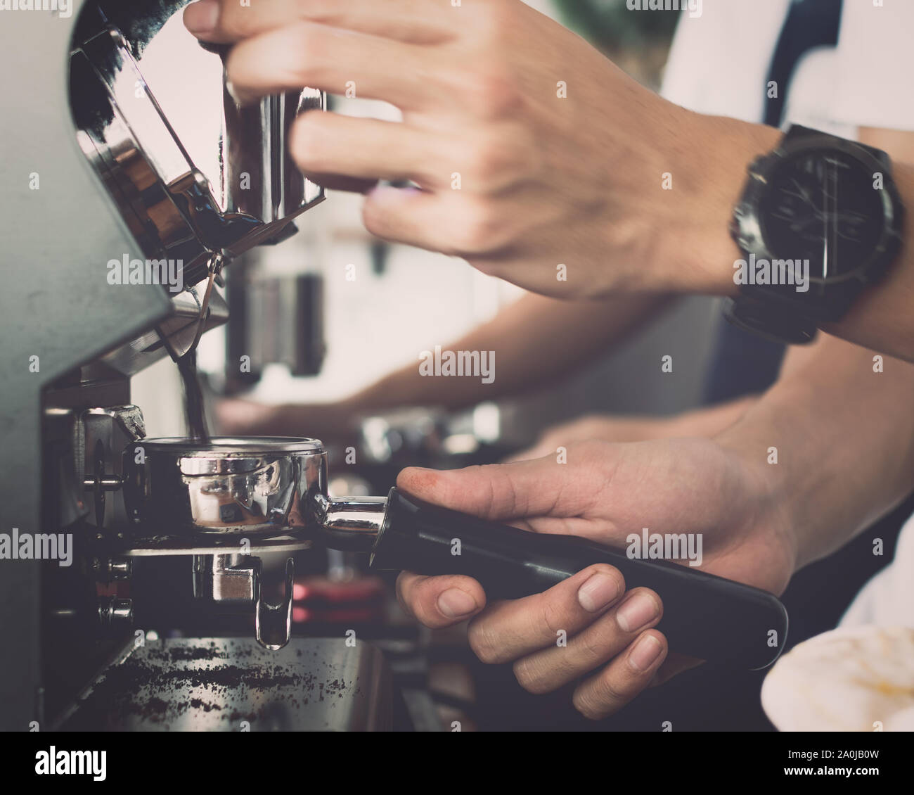 Close up hands of man barista using coffee machine for making coffee in ...