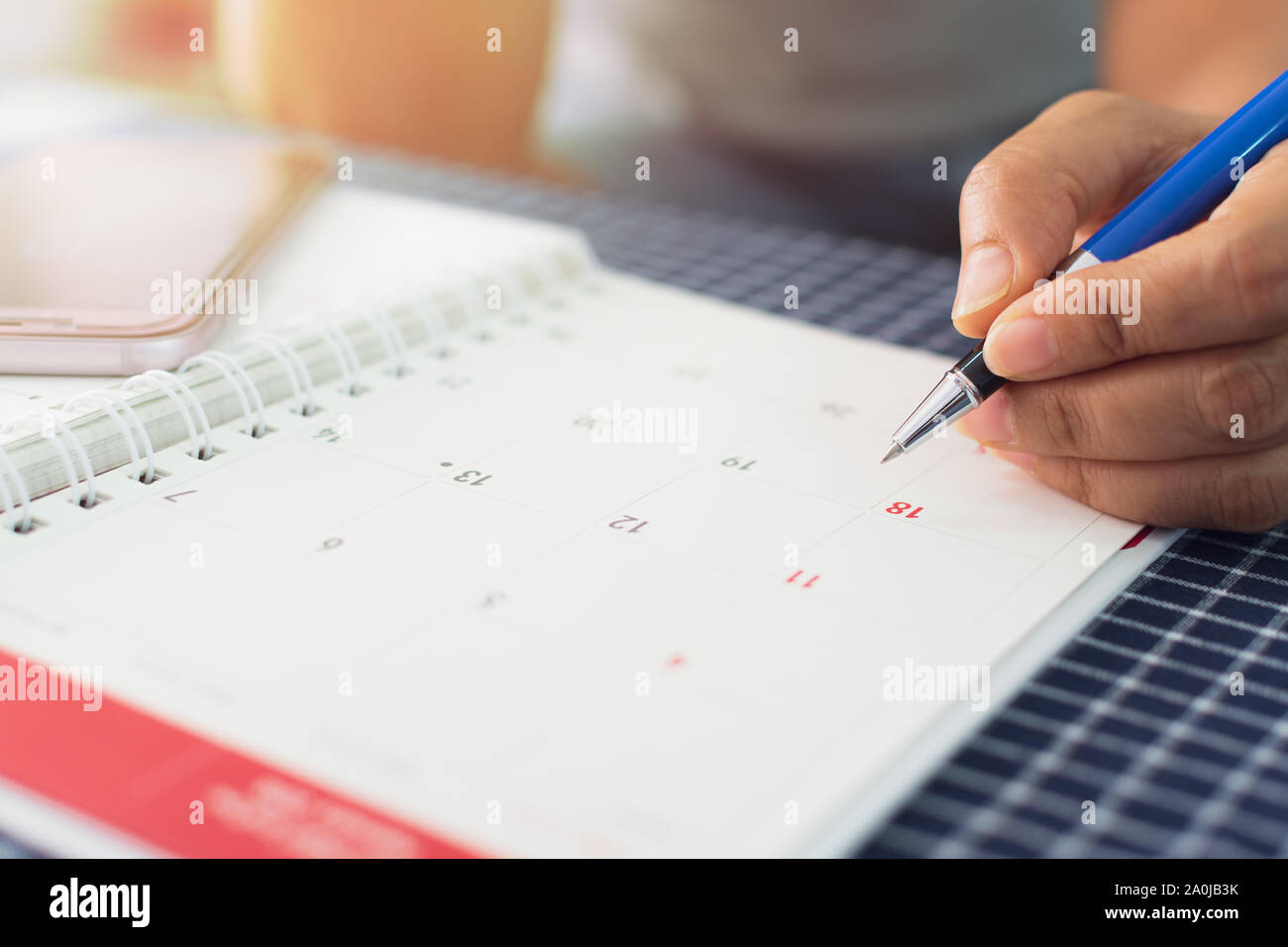 Hands of businesswoman is planning and managing work on the calendar ...