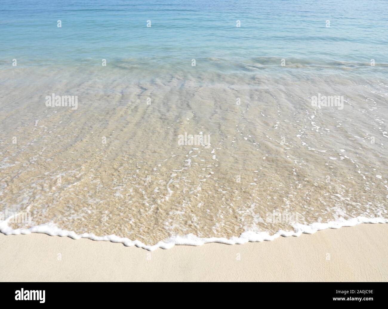 Wave and ripples on a sandy beach Stock Photo - Alamy