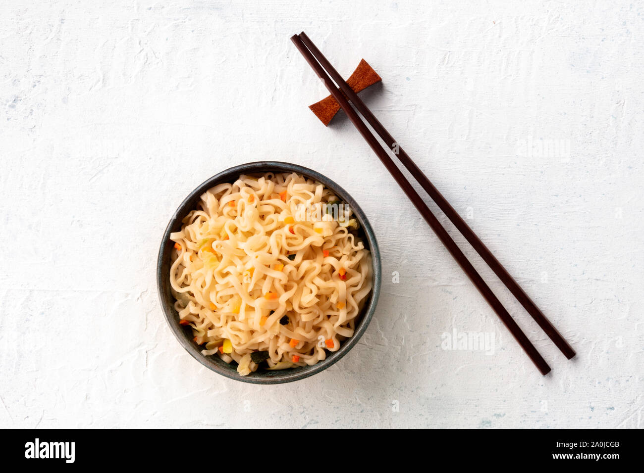 Instant soba noodles with carrot, shot from above on a teal blue ...