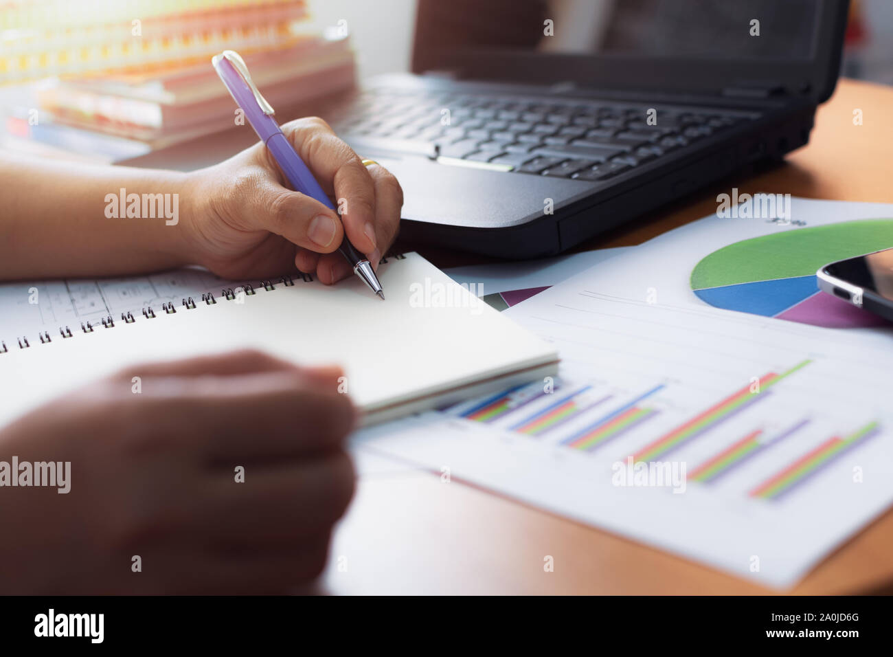 Hand of woman is writing on working desk in office. Business concept ...