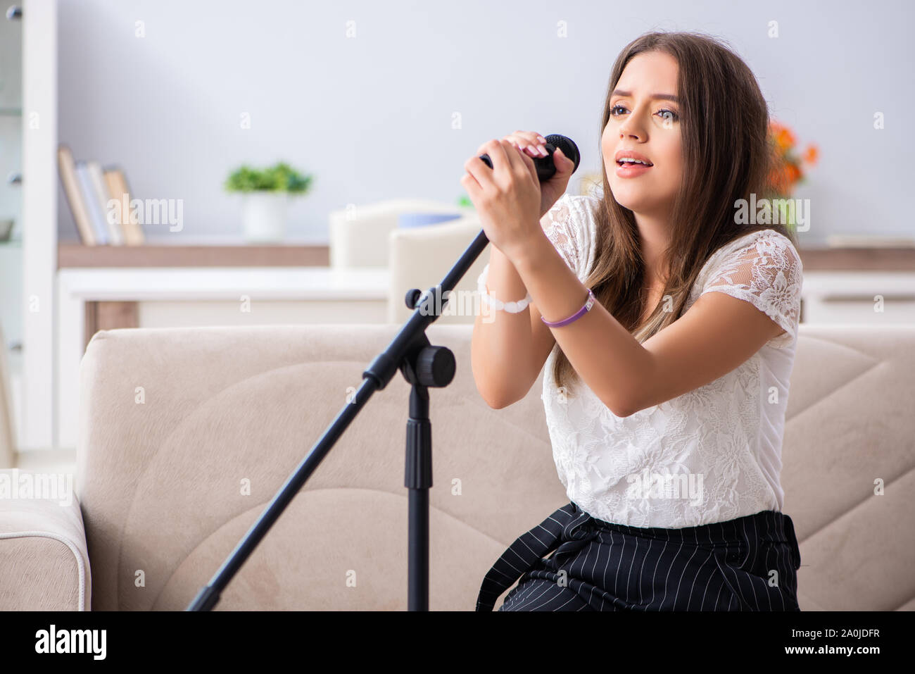 The female beautiful musician singing at home Stock Photo - Alamy