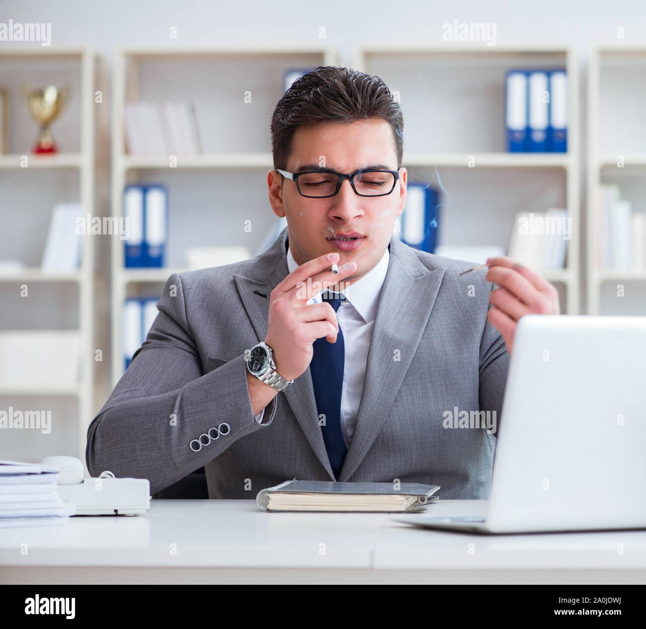 The businessman smoking in office at work Stock Photo - Alamy