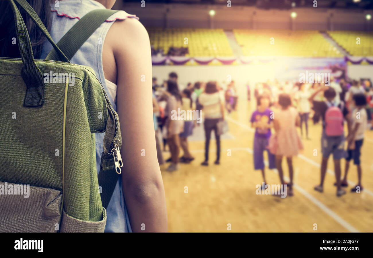 Girl with backpack attend school activities in indoor stadium ...