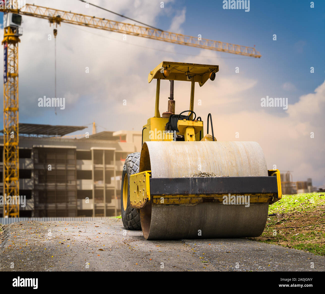 Road roller at construction site with cloudy blue sky Stock Photo - Alamy