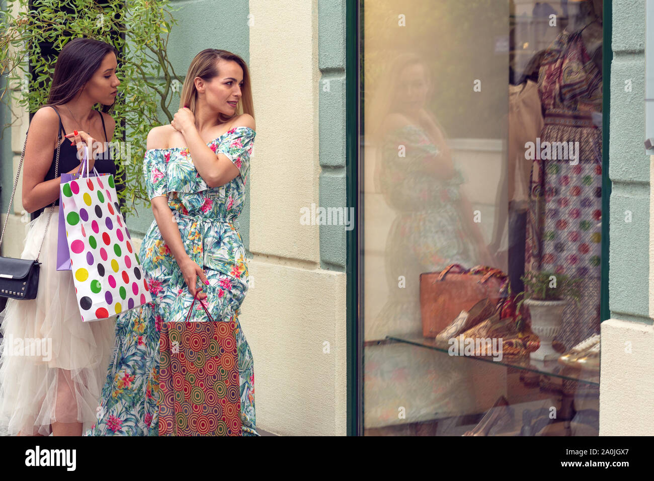 women shopping. Two young women in shopping looking at shop window in ...