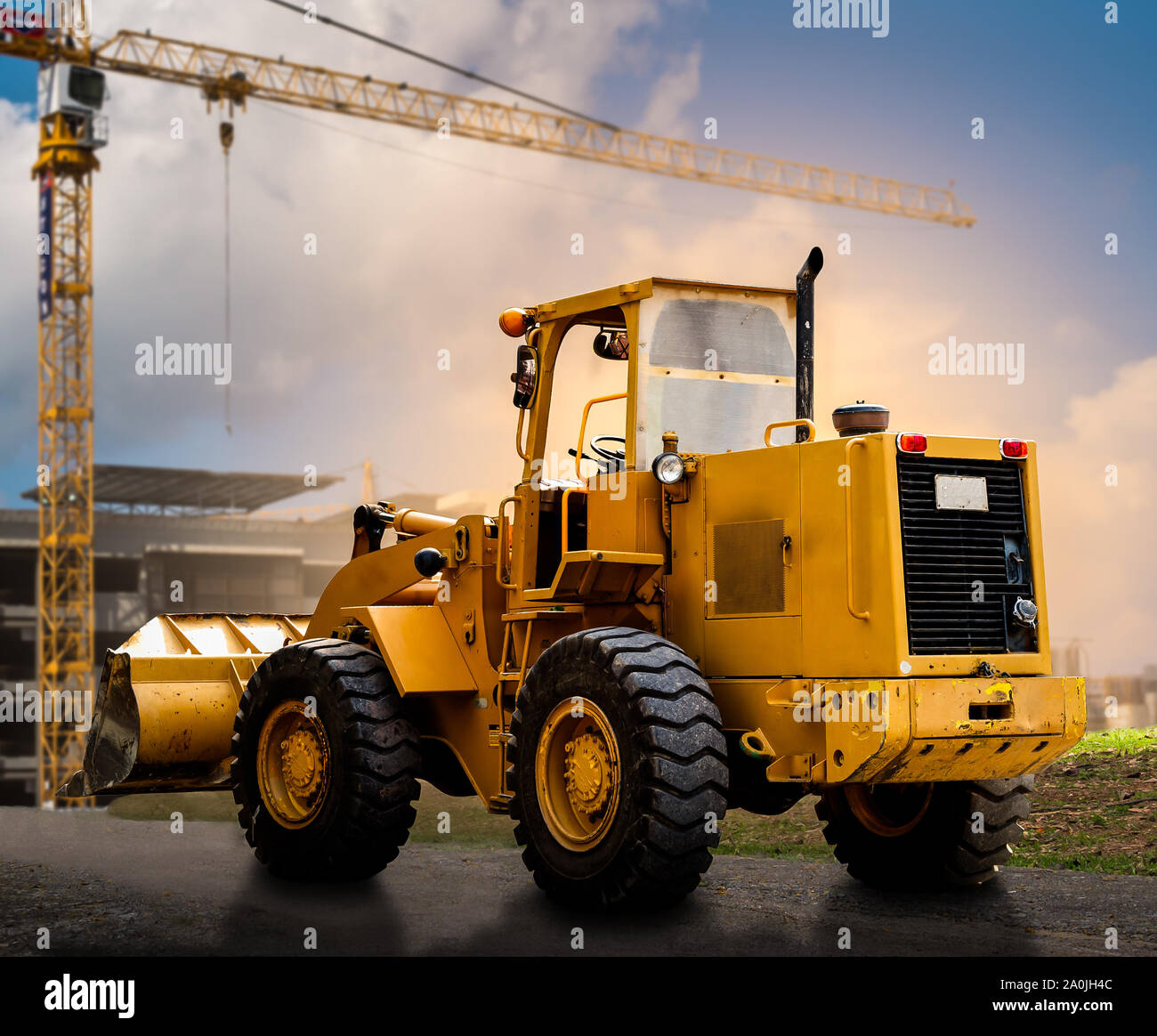 yellow tractor on the road at construction site Stock Photo - Alamy