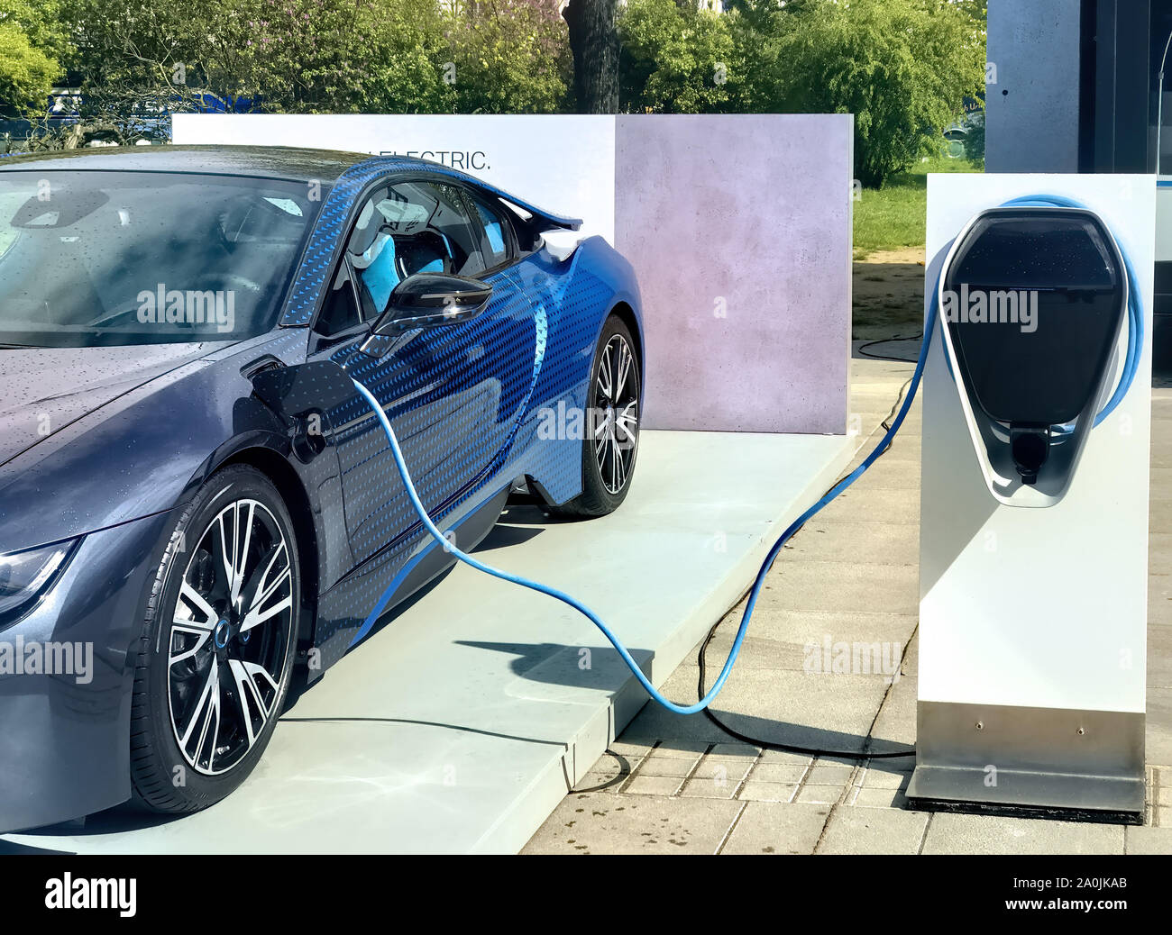 Electric vehicle being plugged in Stock Photo - Alamy