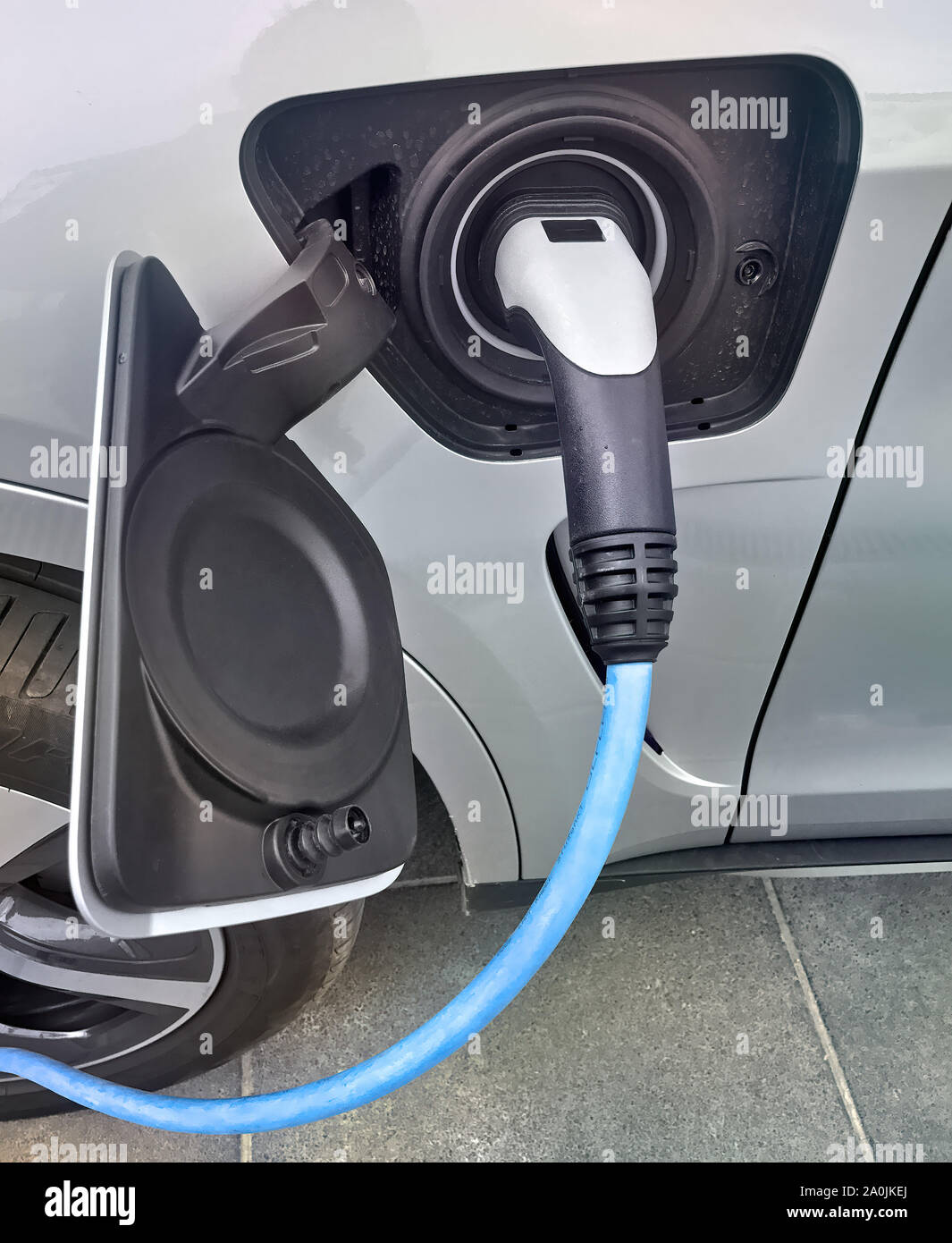 Electric vehicle being plugged in Stock Photo - Alamy