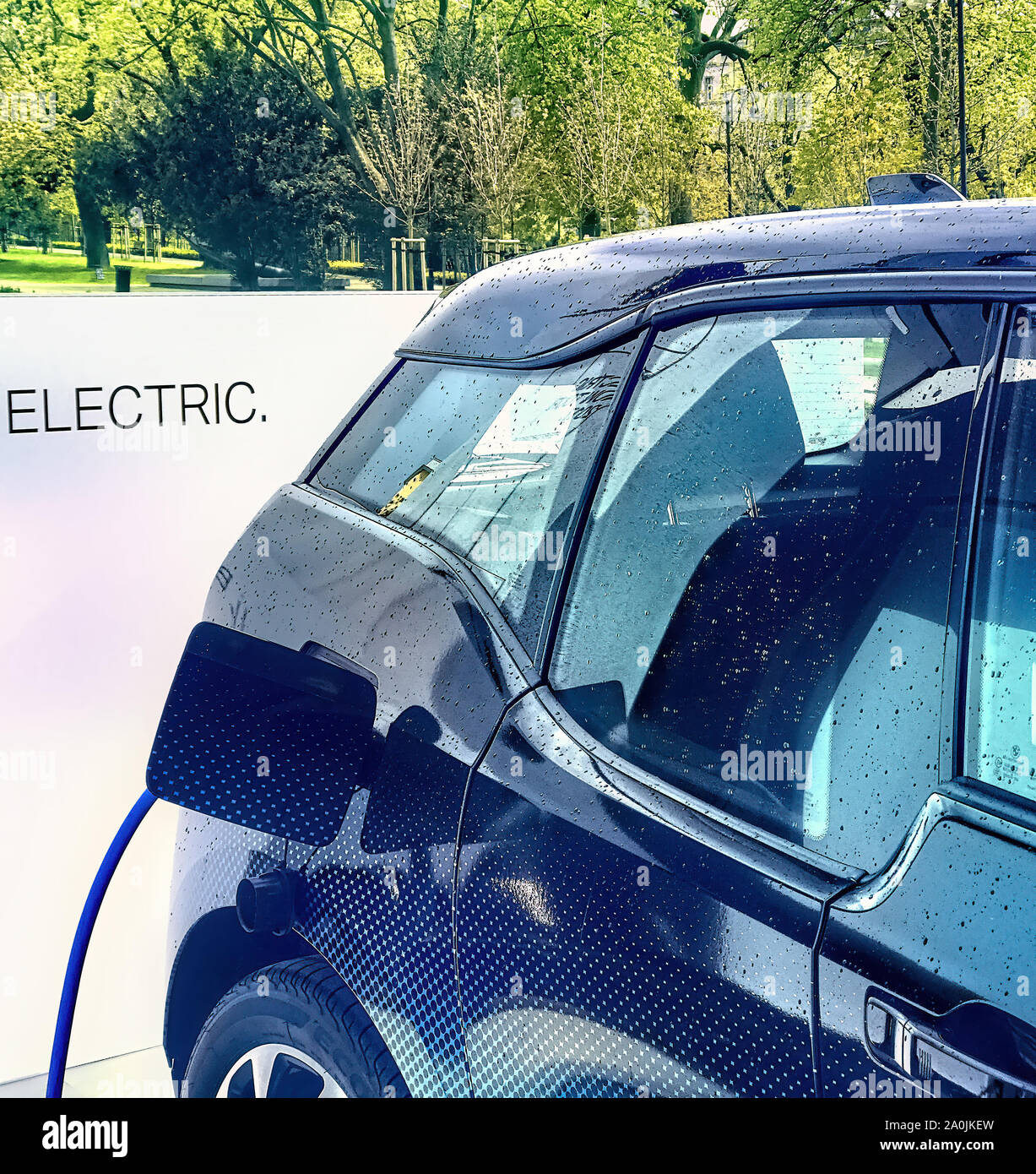 Electric vehicle being plugged in Stock Photo - Alamy