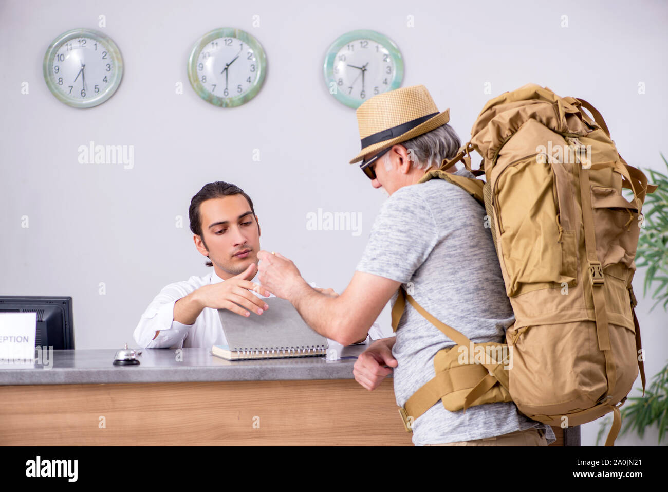 Old backpacker at the hotel reception Stock Photo - Alamy