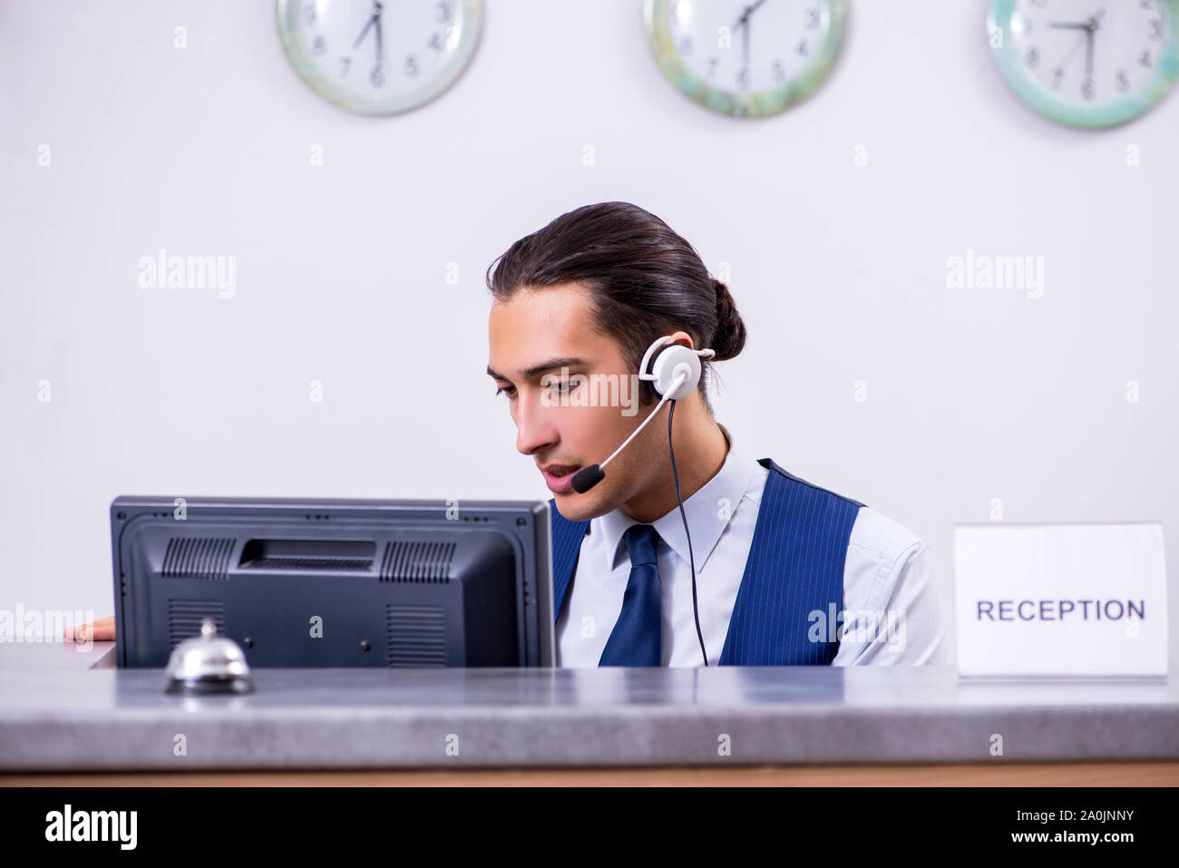 The young man receptionist at the hotel counter Stock Photo - Alamy
