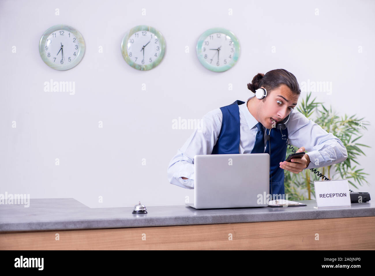 The young man receptionist at the hotel counter Stock Photo - Alamy