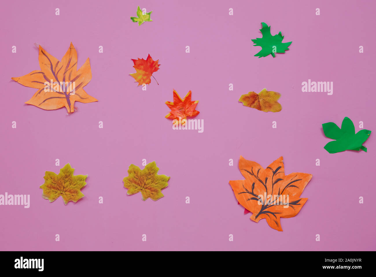 Leaves made of paper on a pink background. Leaves of paper fall red ...