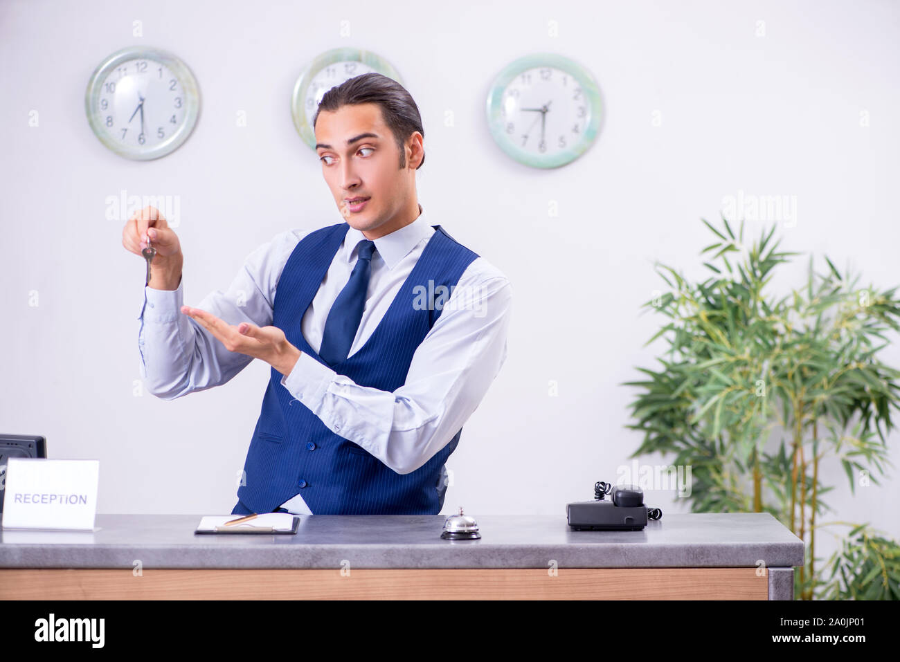 The young man receptionist at the hotel counter Stock Photo - Alamy