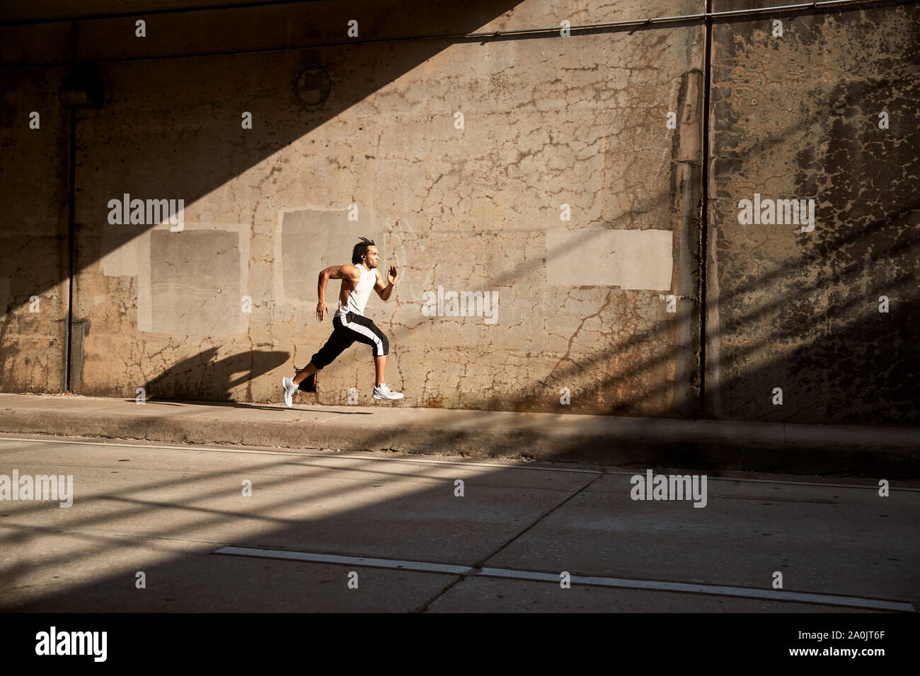 African-American man running on sidewalk Stock Photo - Alamy