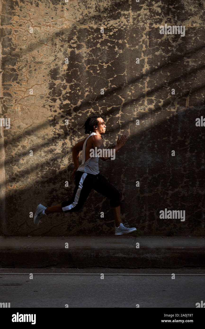 African-American man running on sidewalk Stock Photo - Alamy