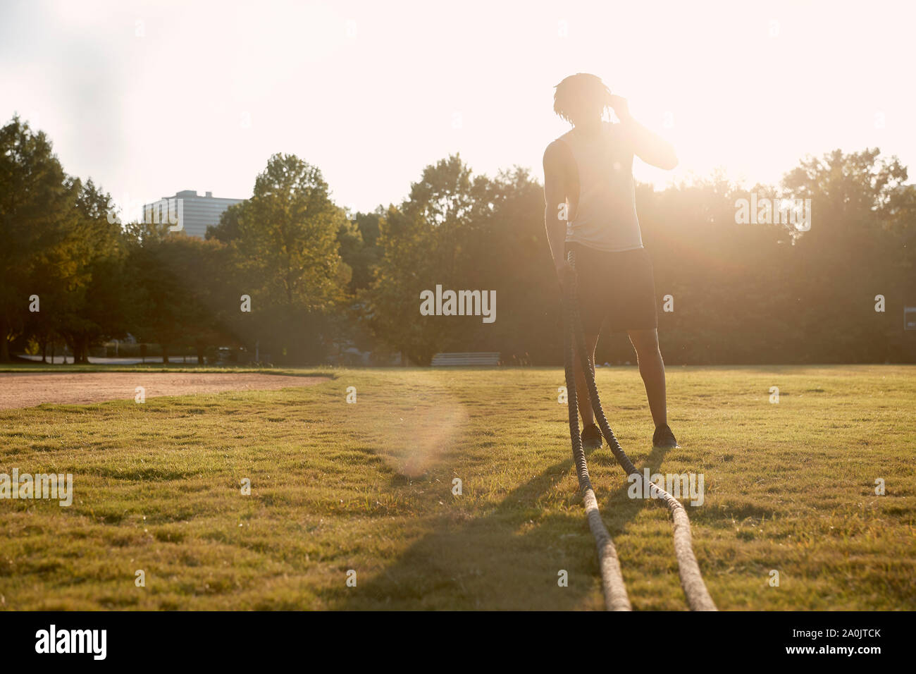 African-American man holding battle ropes in field Stock Photo - Alamy