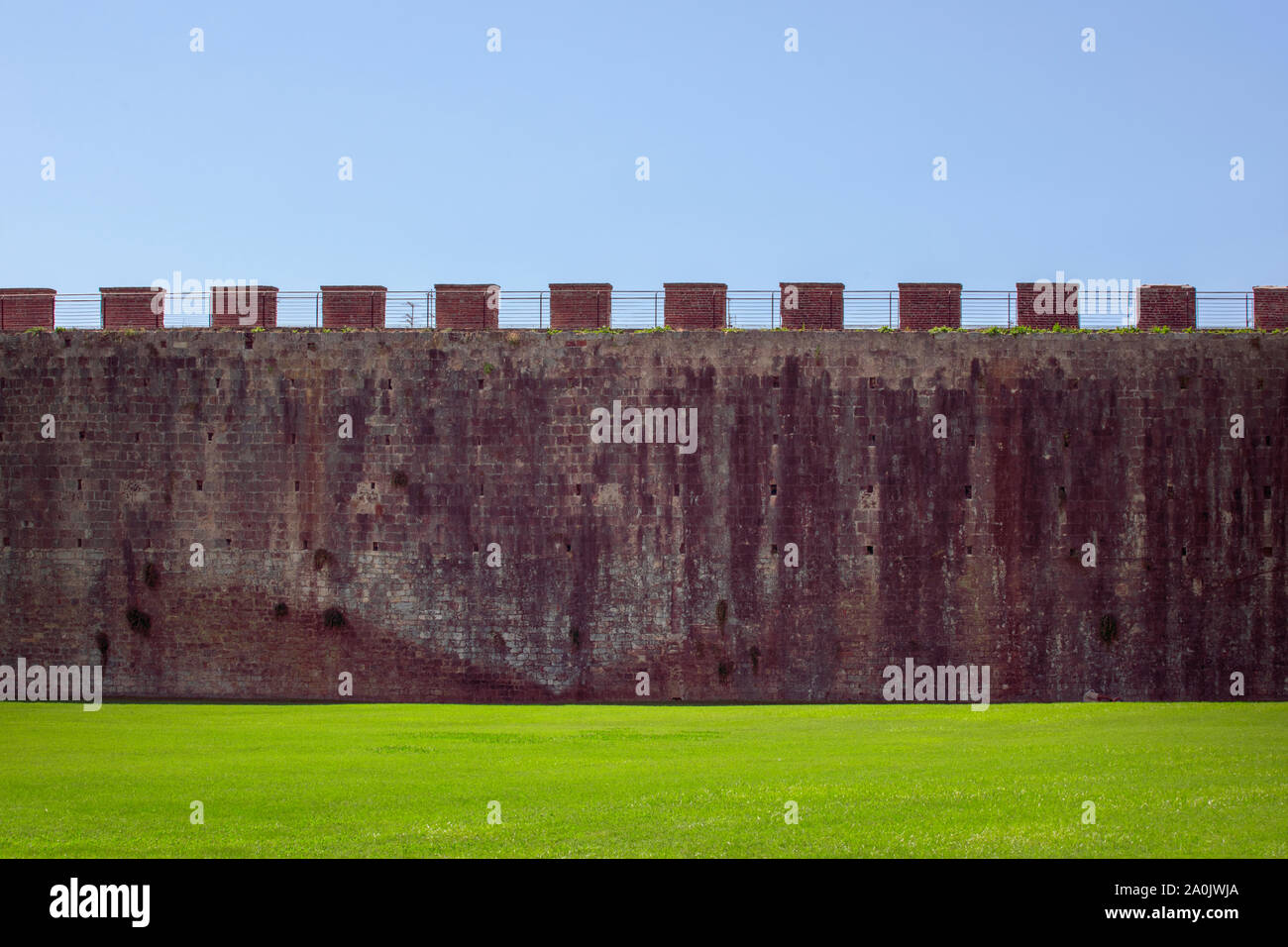 Medieval defensive wall background with green grass and blue sky ...
