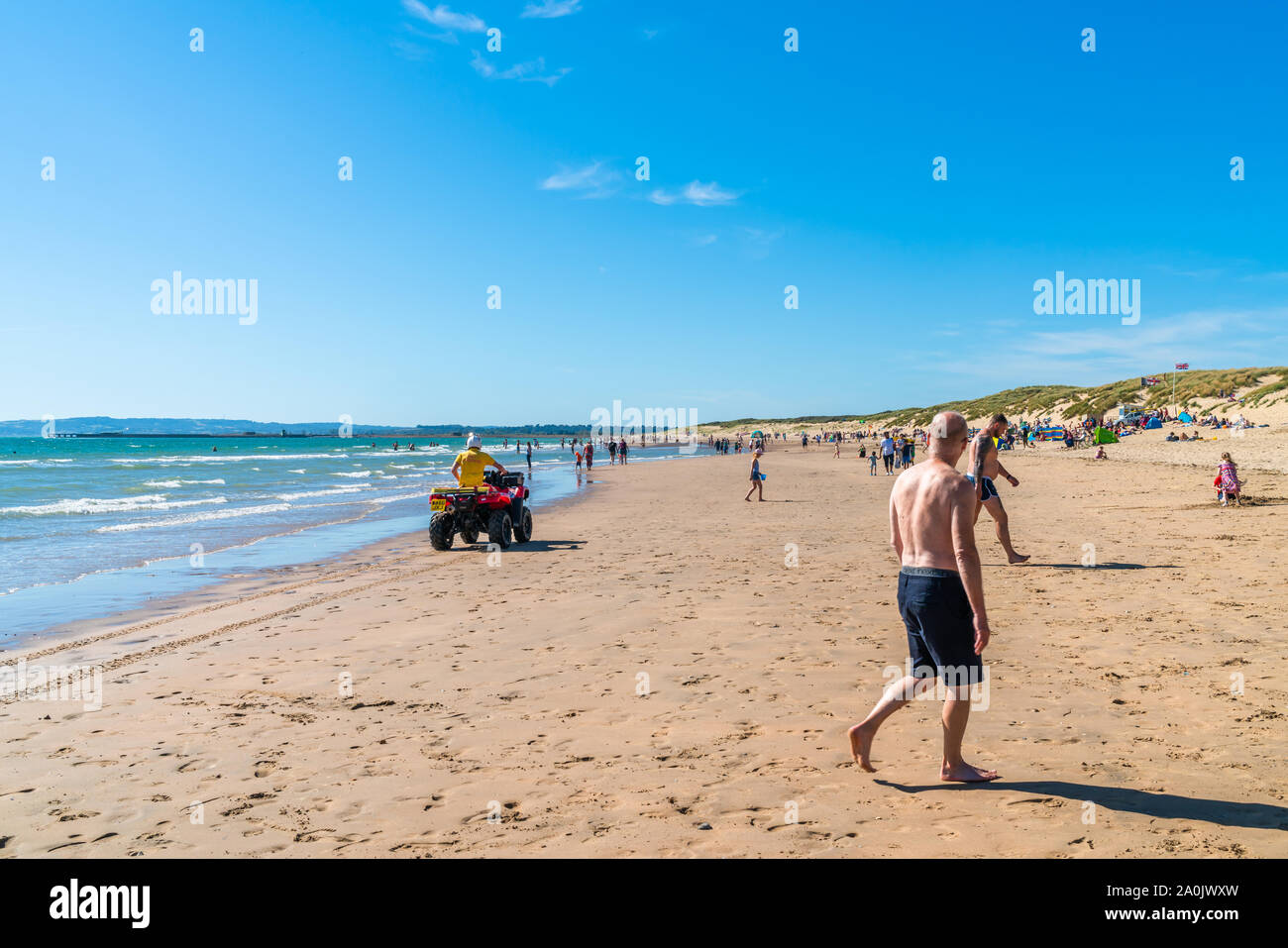 CAMBER SANDS, UK - SEPTEMBER 15, 2019: People relax on the Camber Sands ...