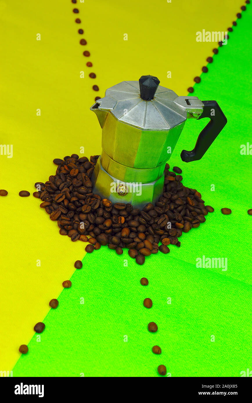 small traditional italian coffee pot on green and yellow background ...