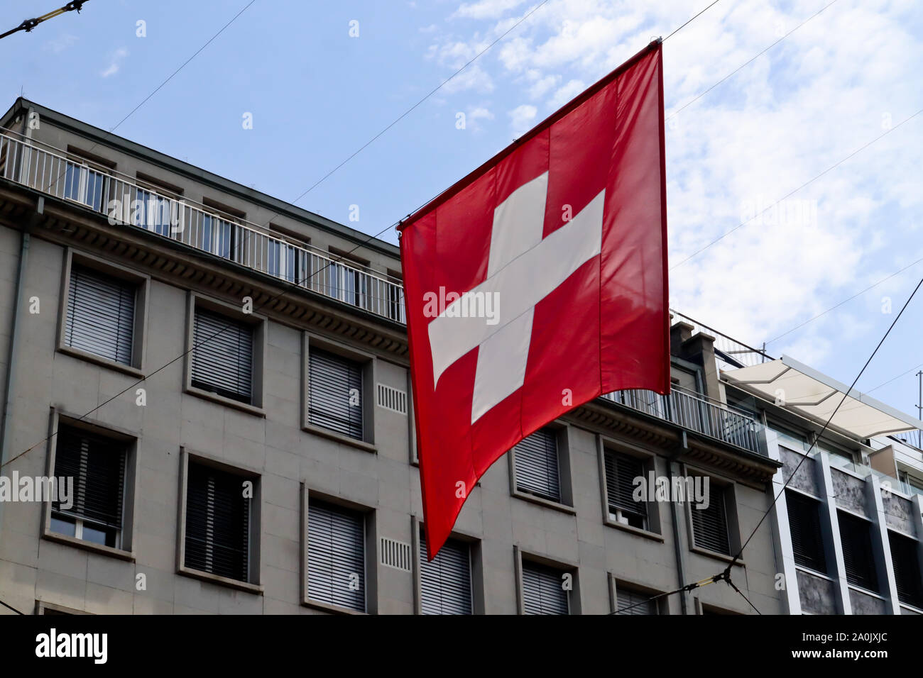 Flag of Switzerland hanging on middle of the street with building and ...