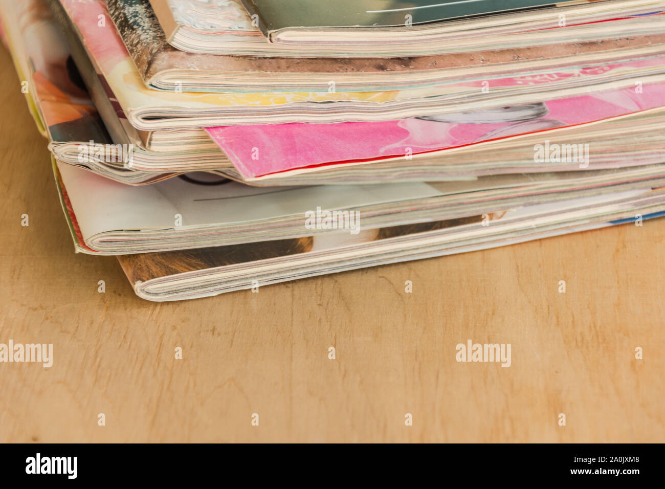 Stack of colorful magazines on the office wooden table. Copy space ...