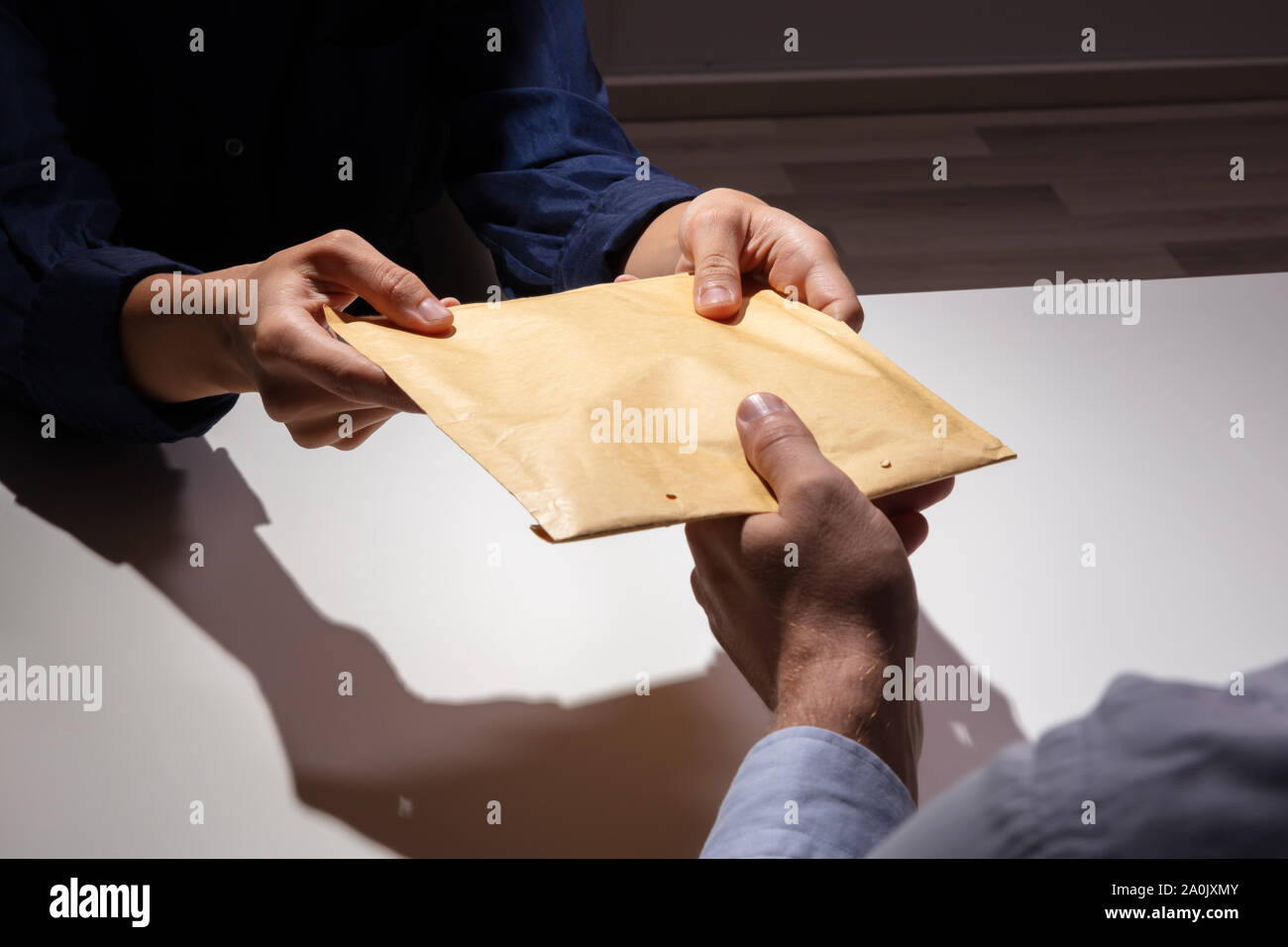An Elevated View Of Man Receiving Brown Bribe Packet From Woman Over ...
