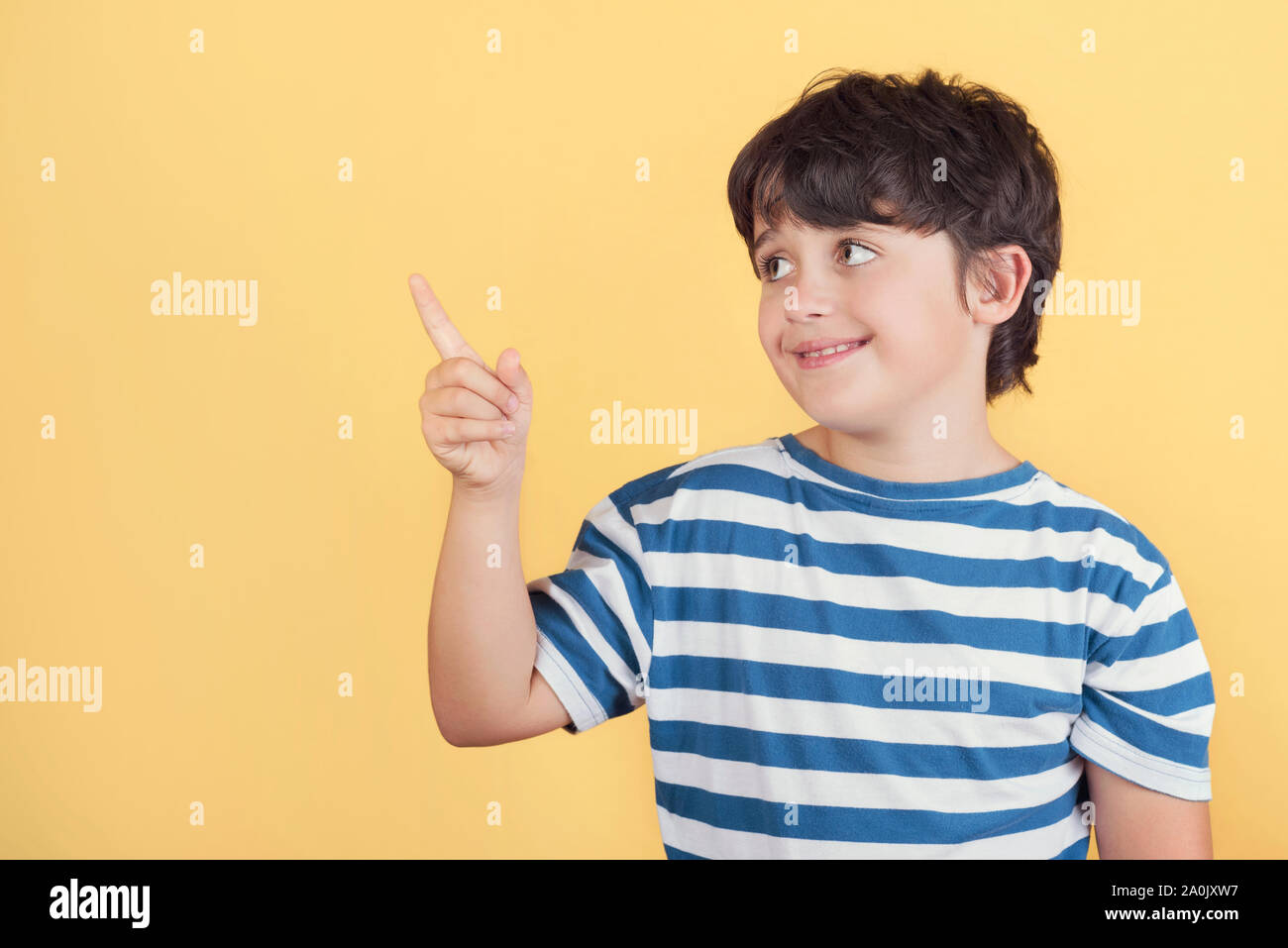 child smiling pointing with hand and finger up to the side with happy ...