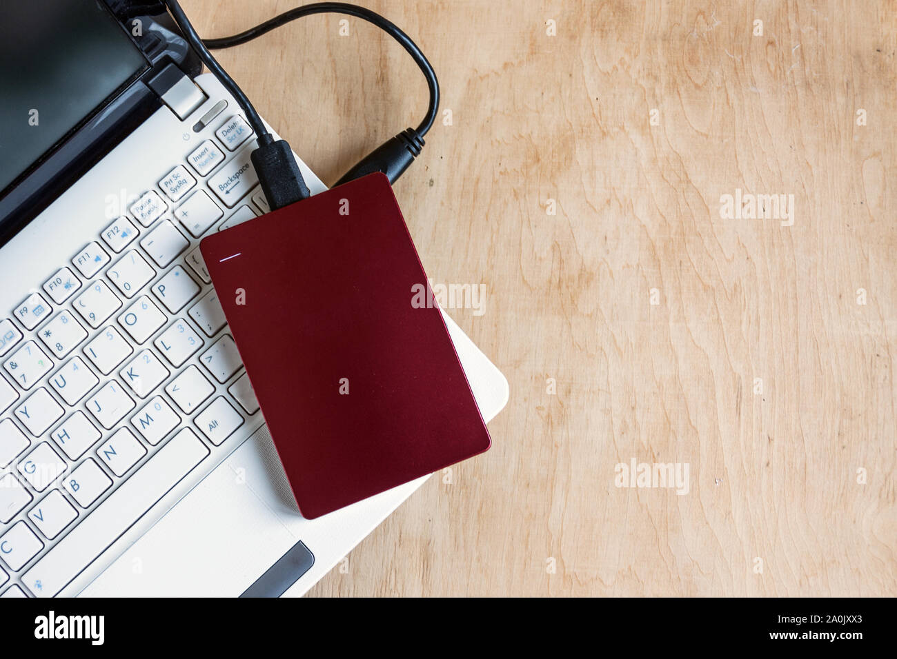 Modern storage, external hard drive and laptop keyboard on wooden table ...