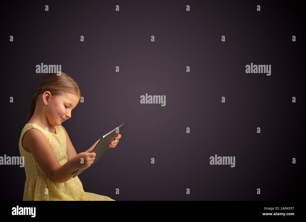 Adorable little girl using tablet with dark empty space Stock Photo - Alamy