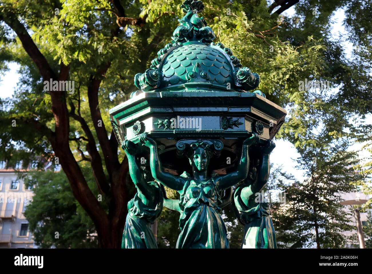 detail of decorative green fountain in Zurich with trees in background ...