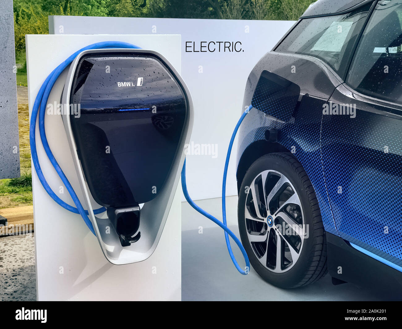 Electric vehicle being plugged in Stock Photo - Alamy