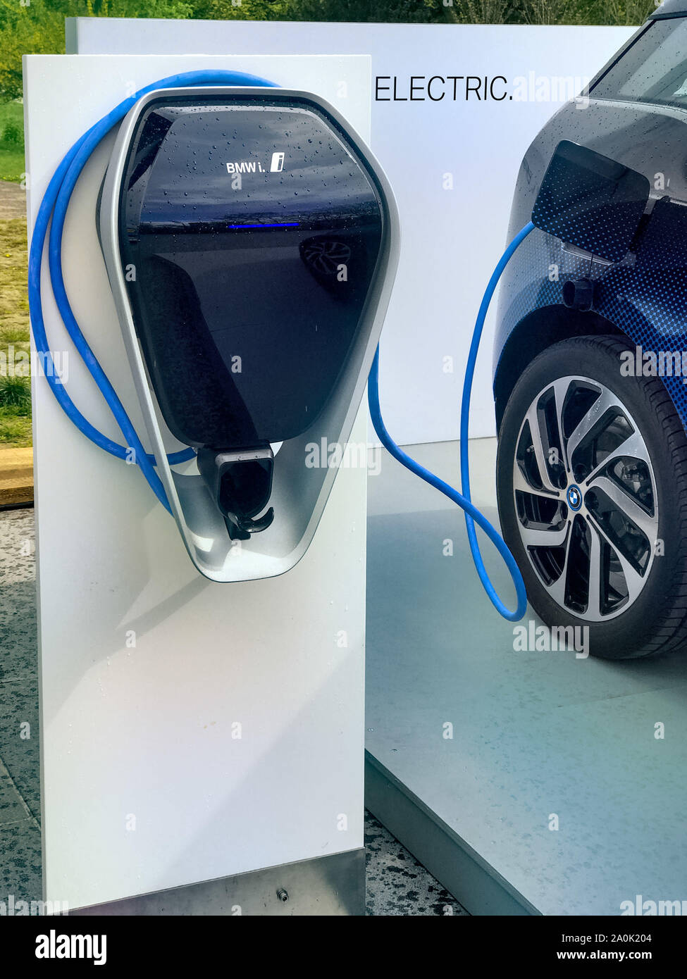 Electric vehicle being plugged in Stock Photo - Alamy