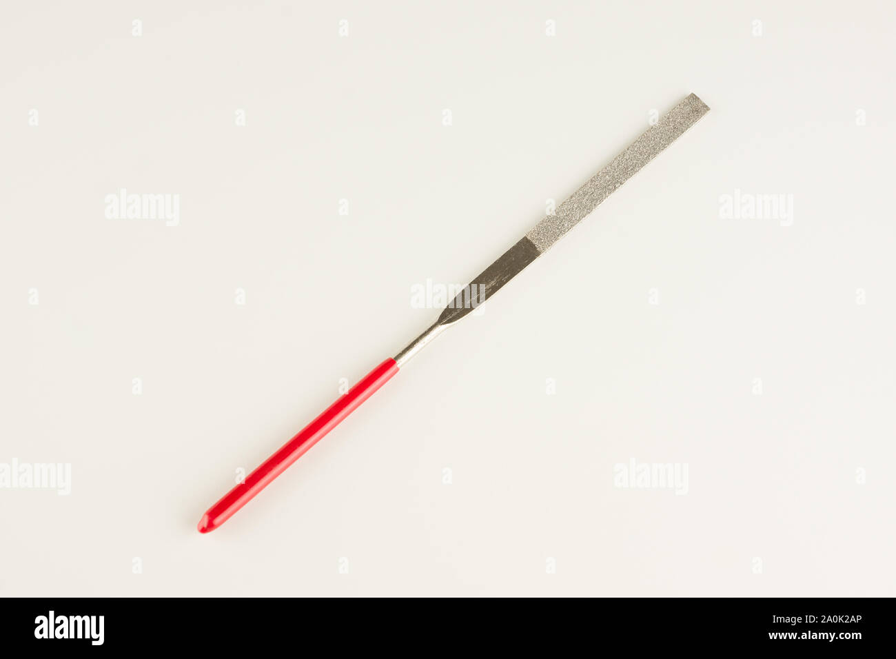 file with a long working part and a red dielectric handle isolated on a ...