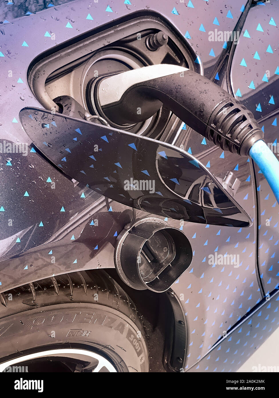 Electric vehicle being plugged in Stock Photo - Alamy