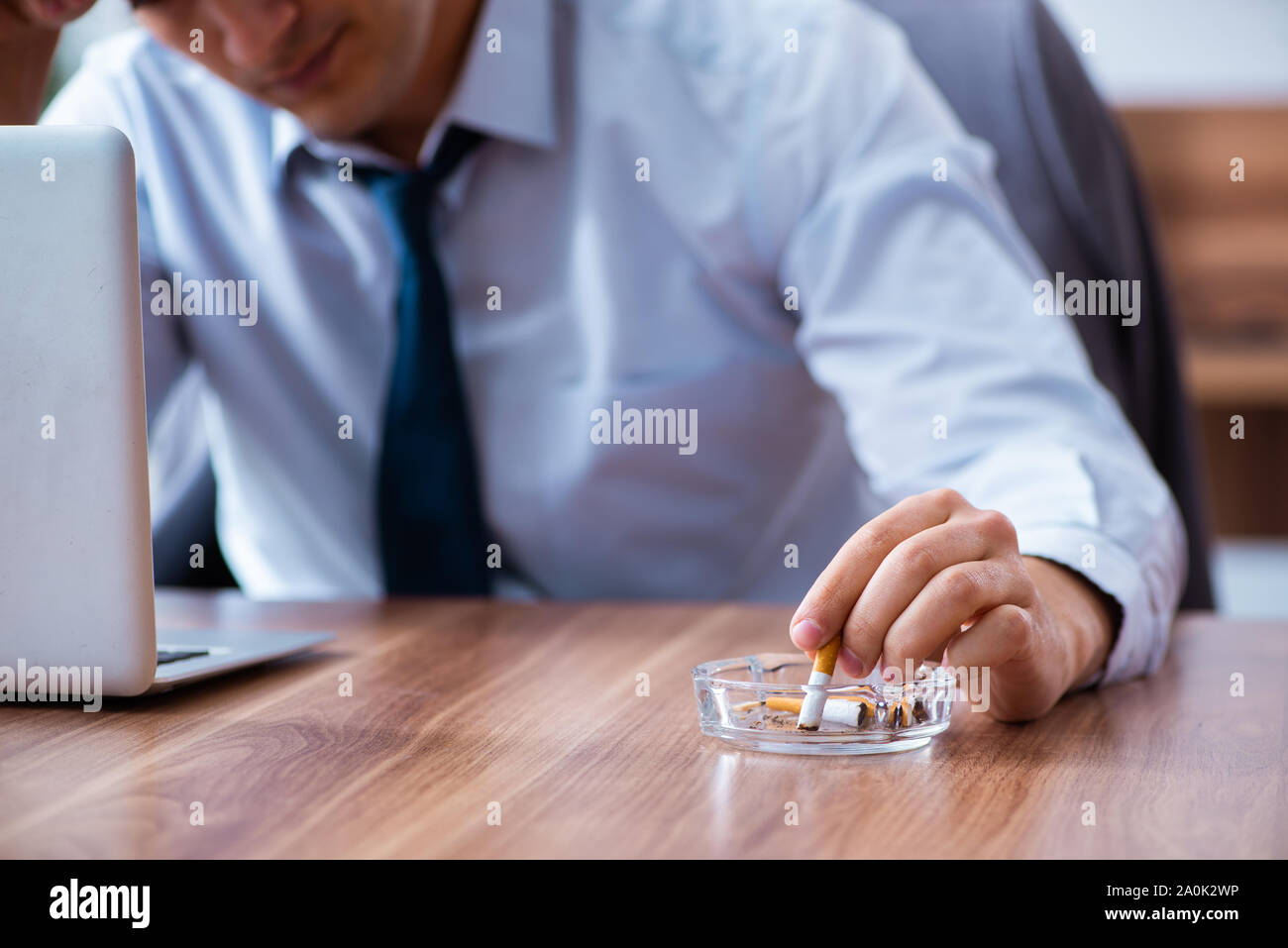 The male employee smoking cigarettes at workplace Stock Photo - Alamy