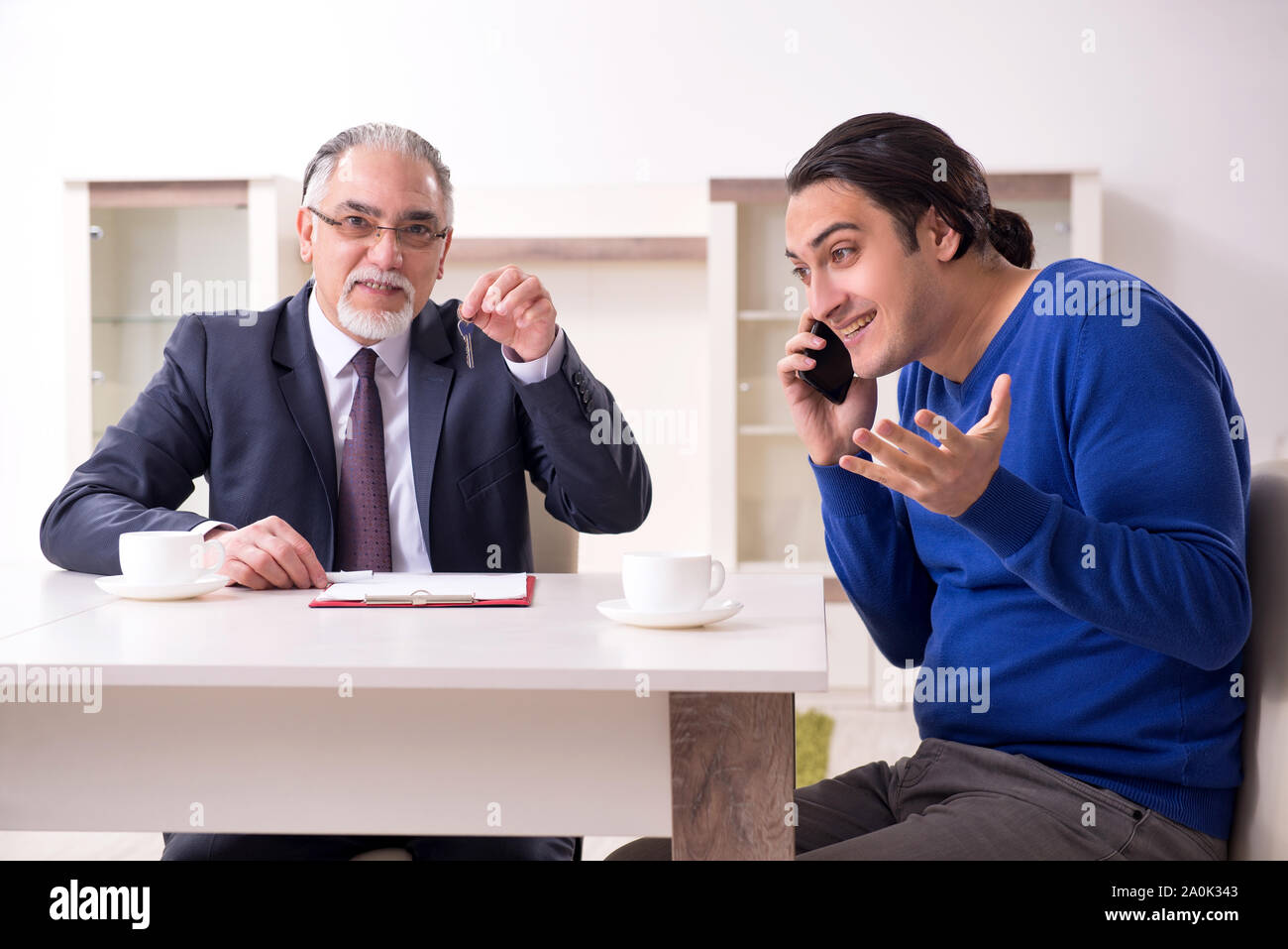 The male real estate agent and male client in the apartment Stock Photo ...