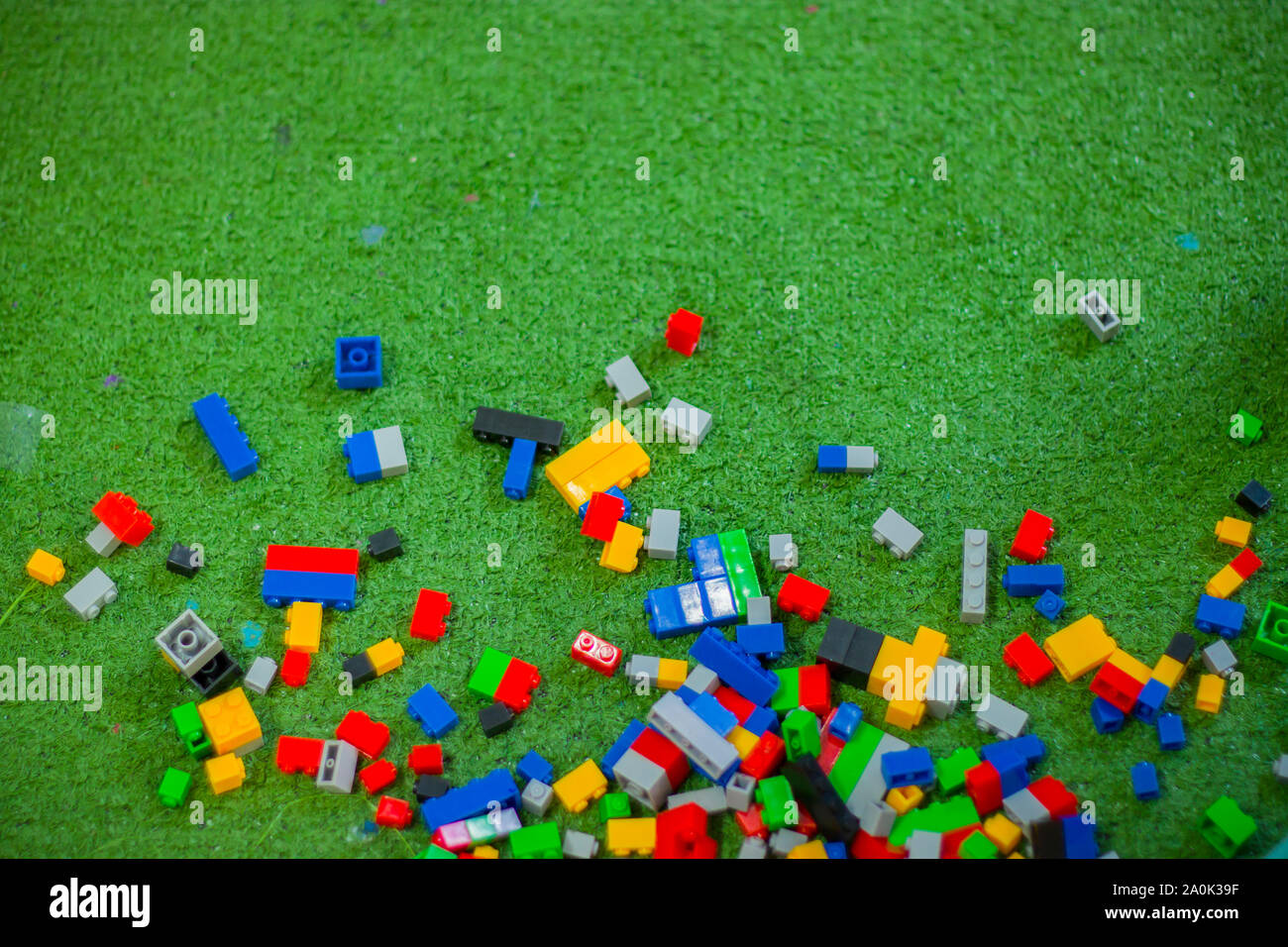 Colored toy bricks with place on green ground very messy. High ...