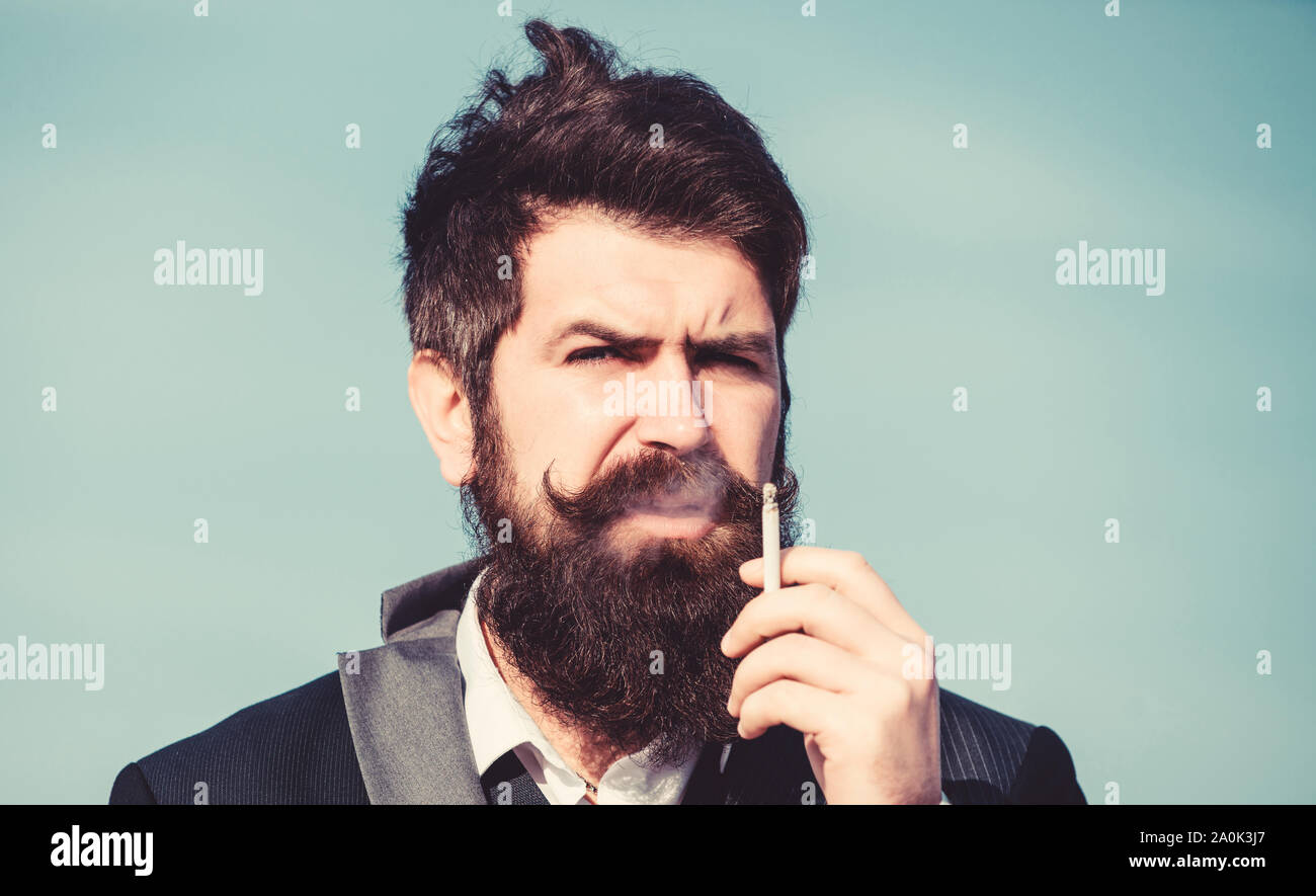 Man with beard and mustache hold cigarette. Bearded hipster smoking ...
