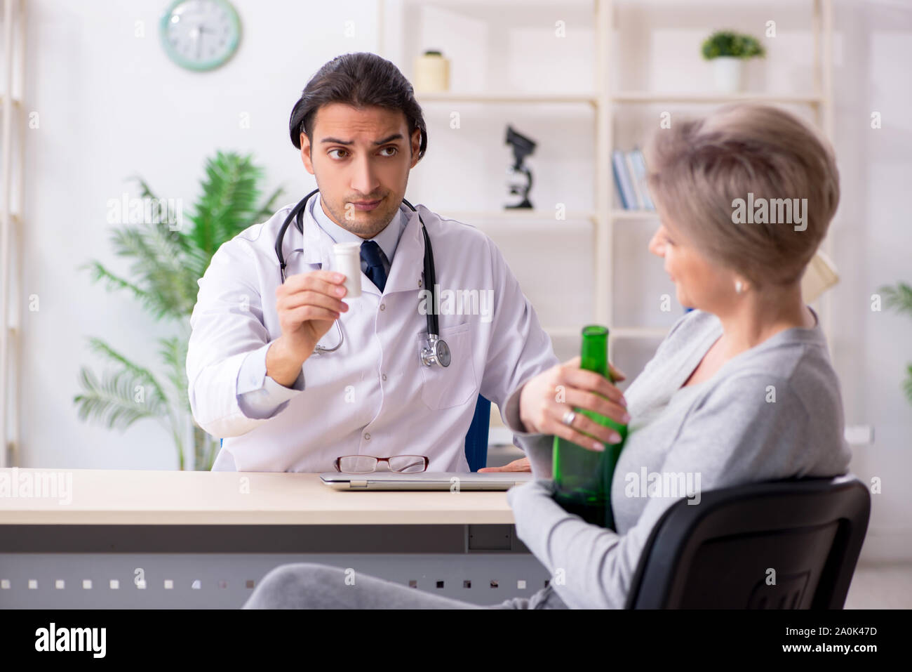 The female alcoholic visiting young male doctor Stock Photo - Alamy