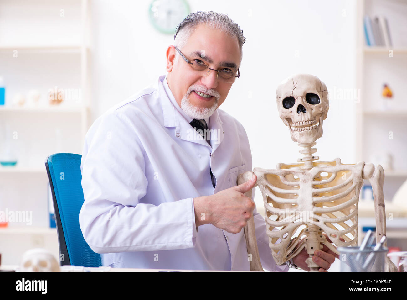 The aged male doctor with skeleton Stock Photo - Alamy